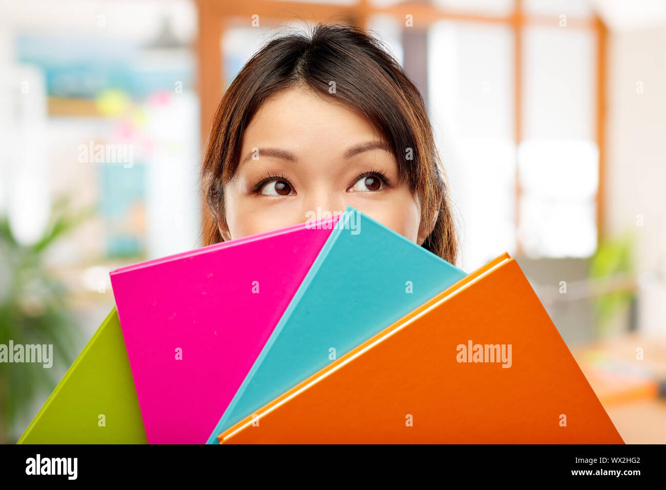 asian woman or student hiding behind notebooks Stock Photo - Alamy
