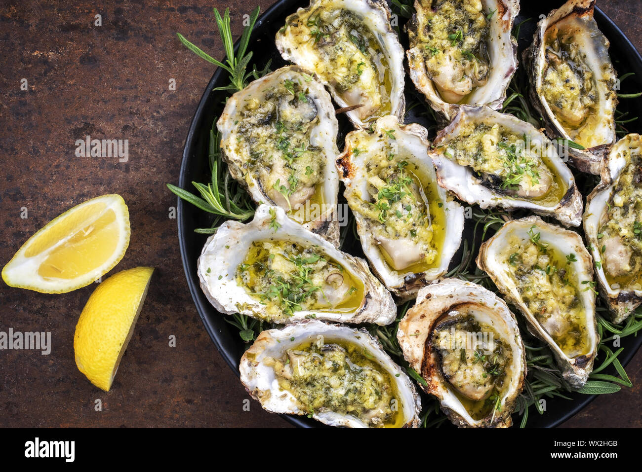 Barbecue overbaked fresh opened oyster with garlic Stock Photo - Alamy