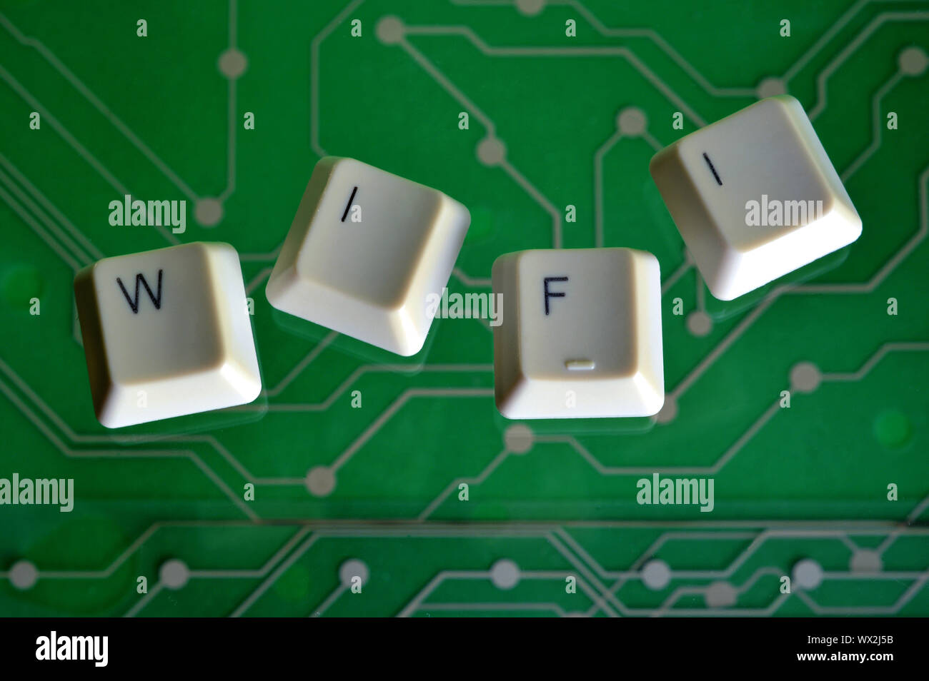 Keyboard keys form the word WI FI on green electric circuit in the ...