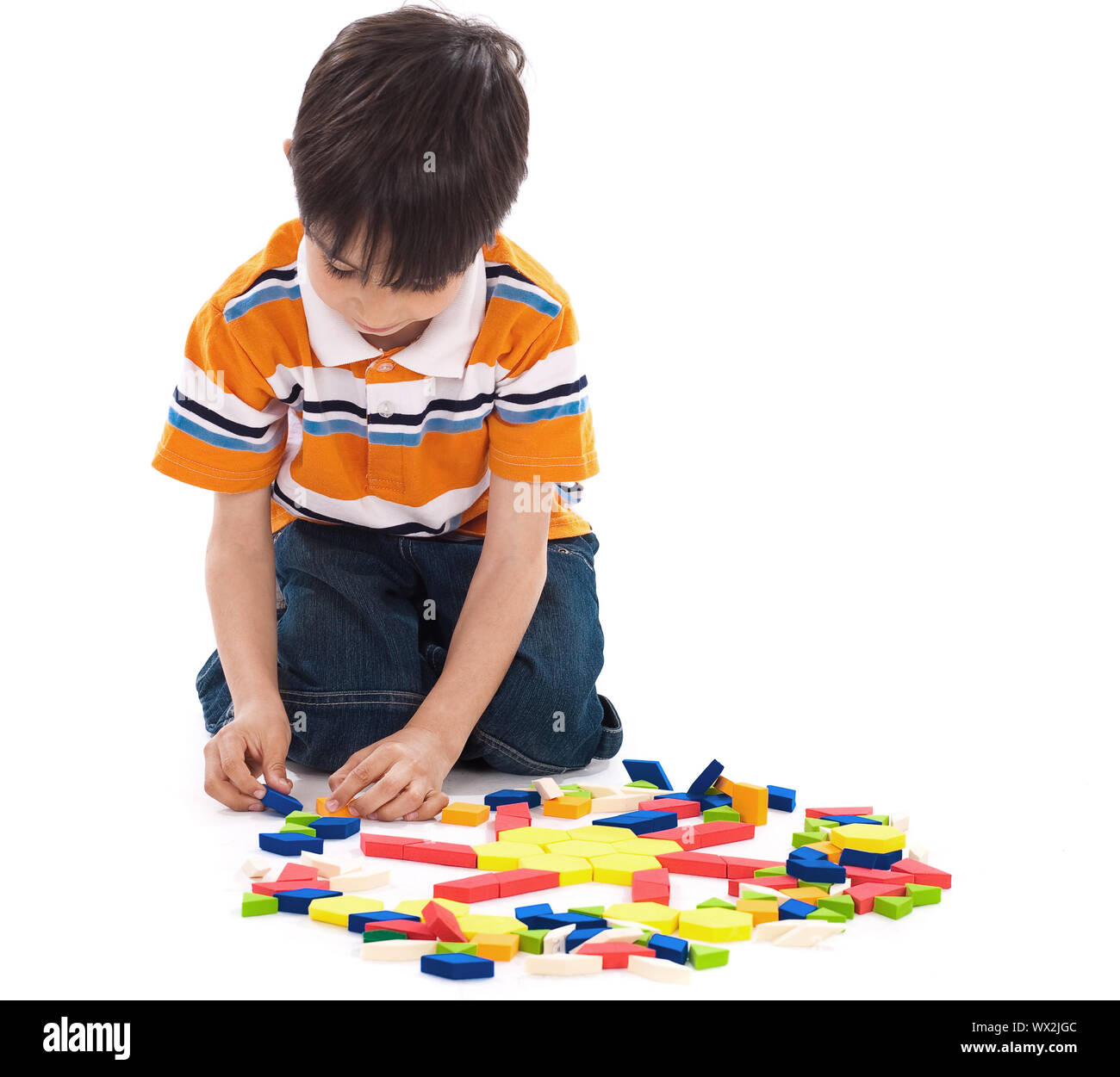 Adorable caucasian boy joining the blocks while playing on white ...