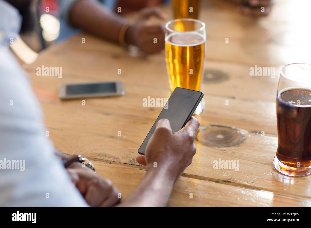 man with smartphone drinking beer at bar or pub Stock Photo - Alamy