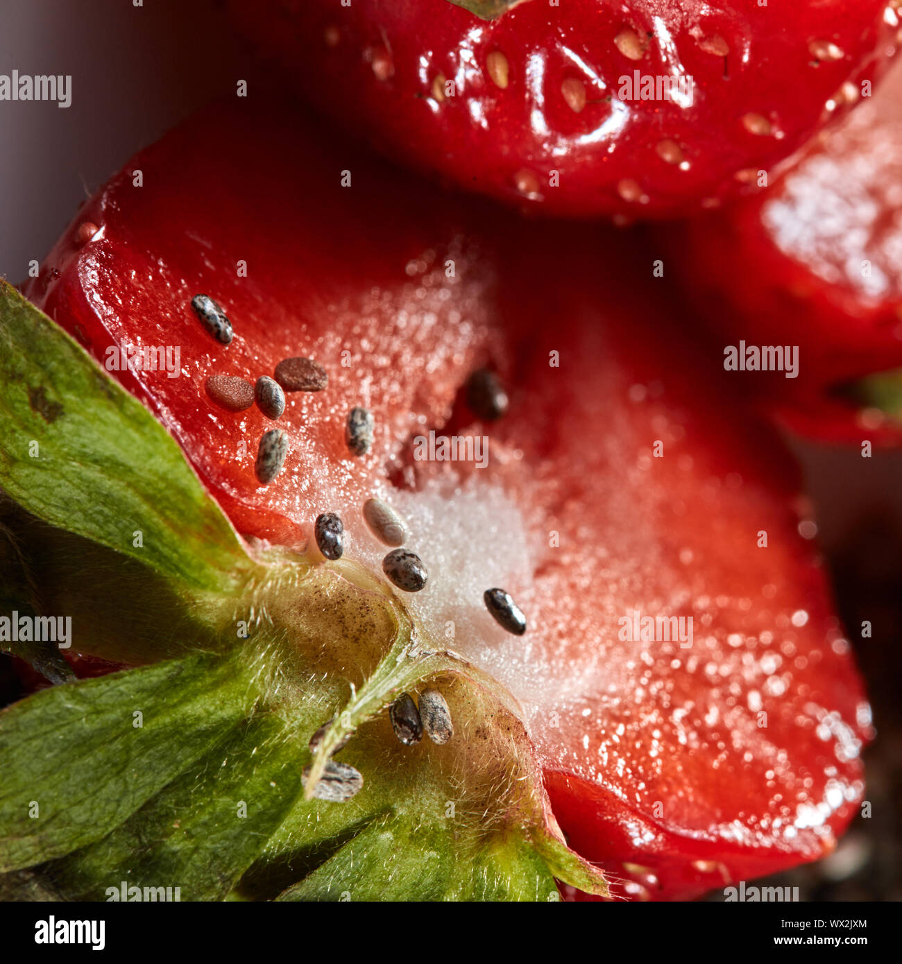 Close up of half of red ripe strawberry with seeds as a background ...
