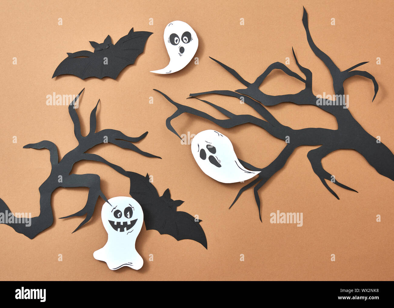 Paper tree branches flying ghosts and bats on a brown background with ...