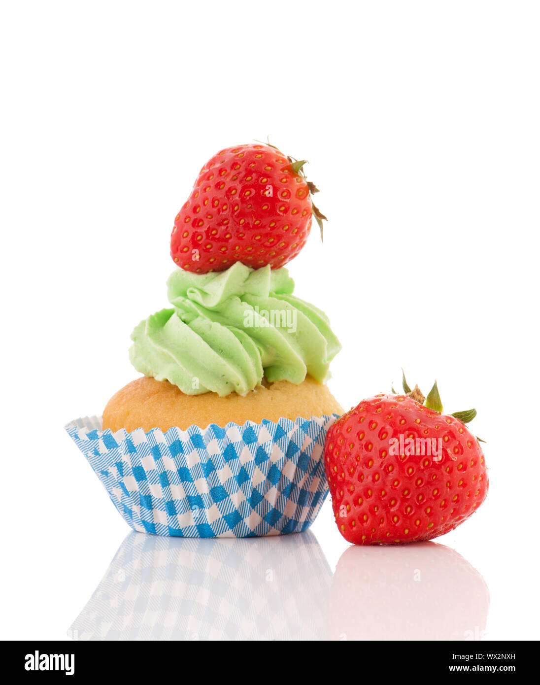 Blue and green cupcake with butter cream and strawberries isolated over ...