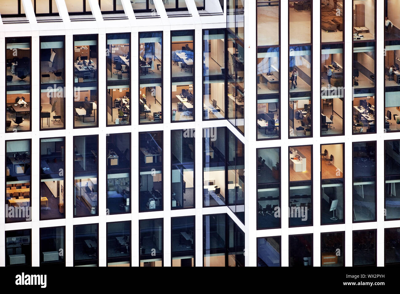 High-rise office building with glass windows, offices with people at ...