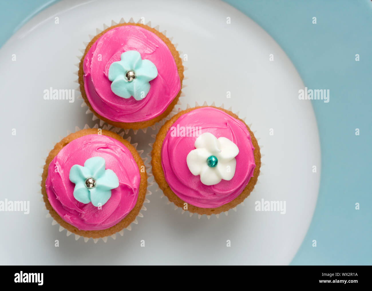Three cupcakes on a plate Stock Photo - Alamy