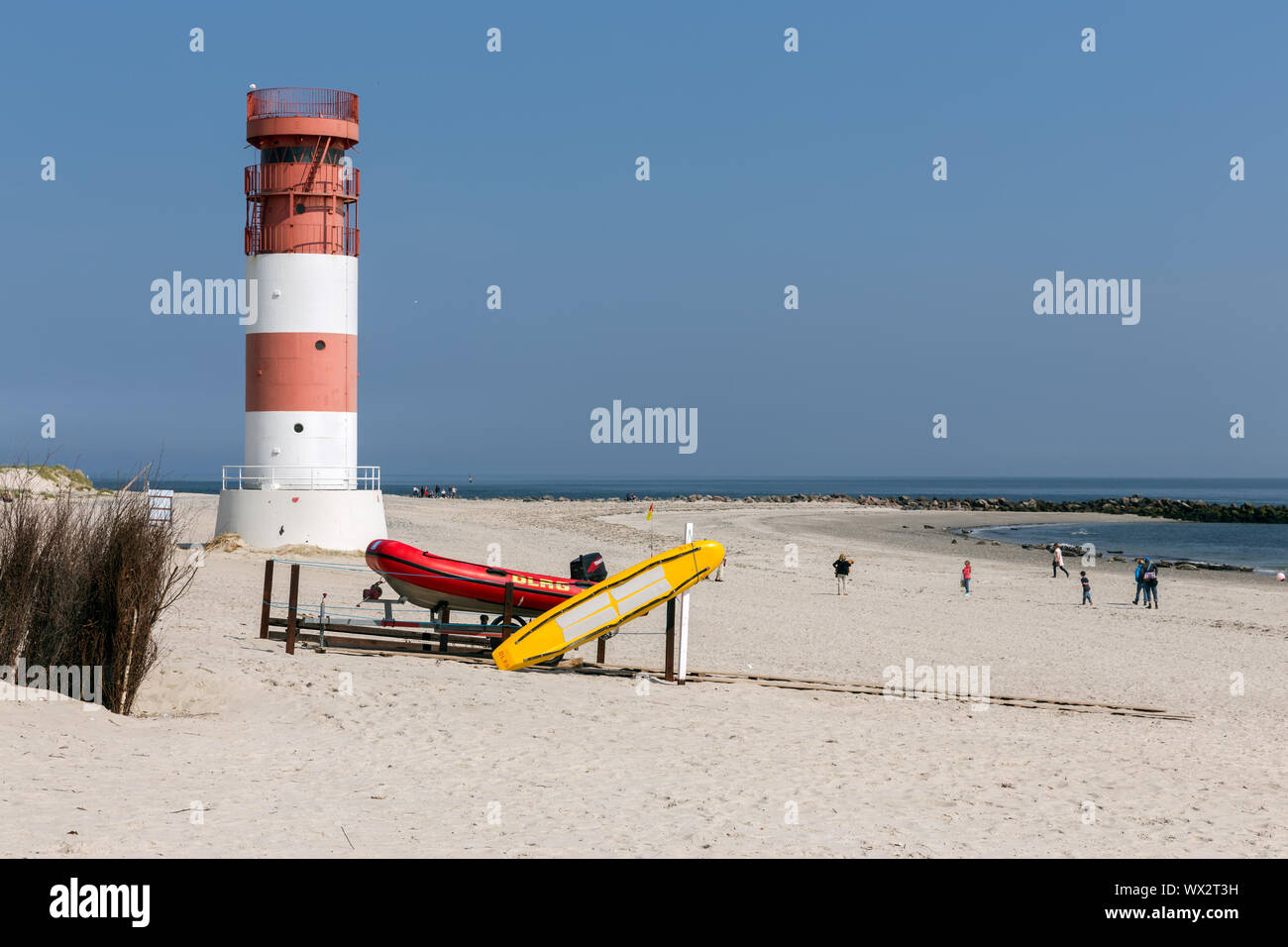 Lighthouse and tourists watching seals at beach of German island Dune ...
