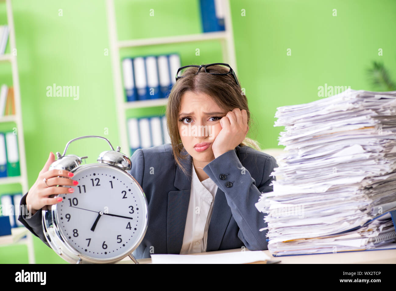 Young female employee very busy with ongoing paperwork in time m Stock ...