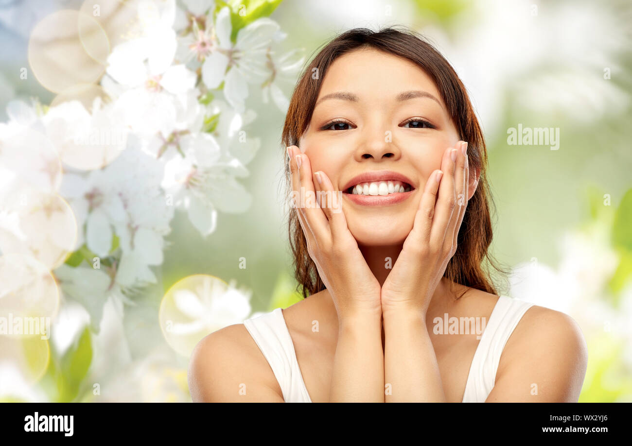 happy smiling young asian woman touching her face Stock Photo - Alamy