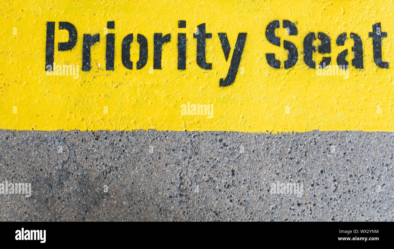 Bright Yellow Stencil Priority Seat Warning Sign Stock Photo - Alamy
