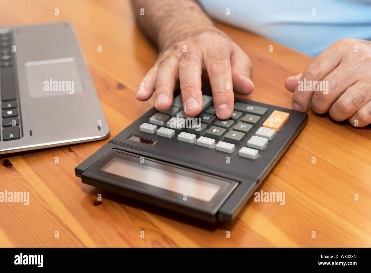 Man using calculator, calculating bills at home Stock Photo - Alamy