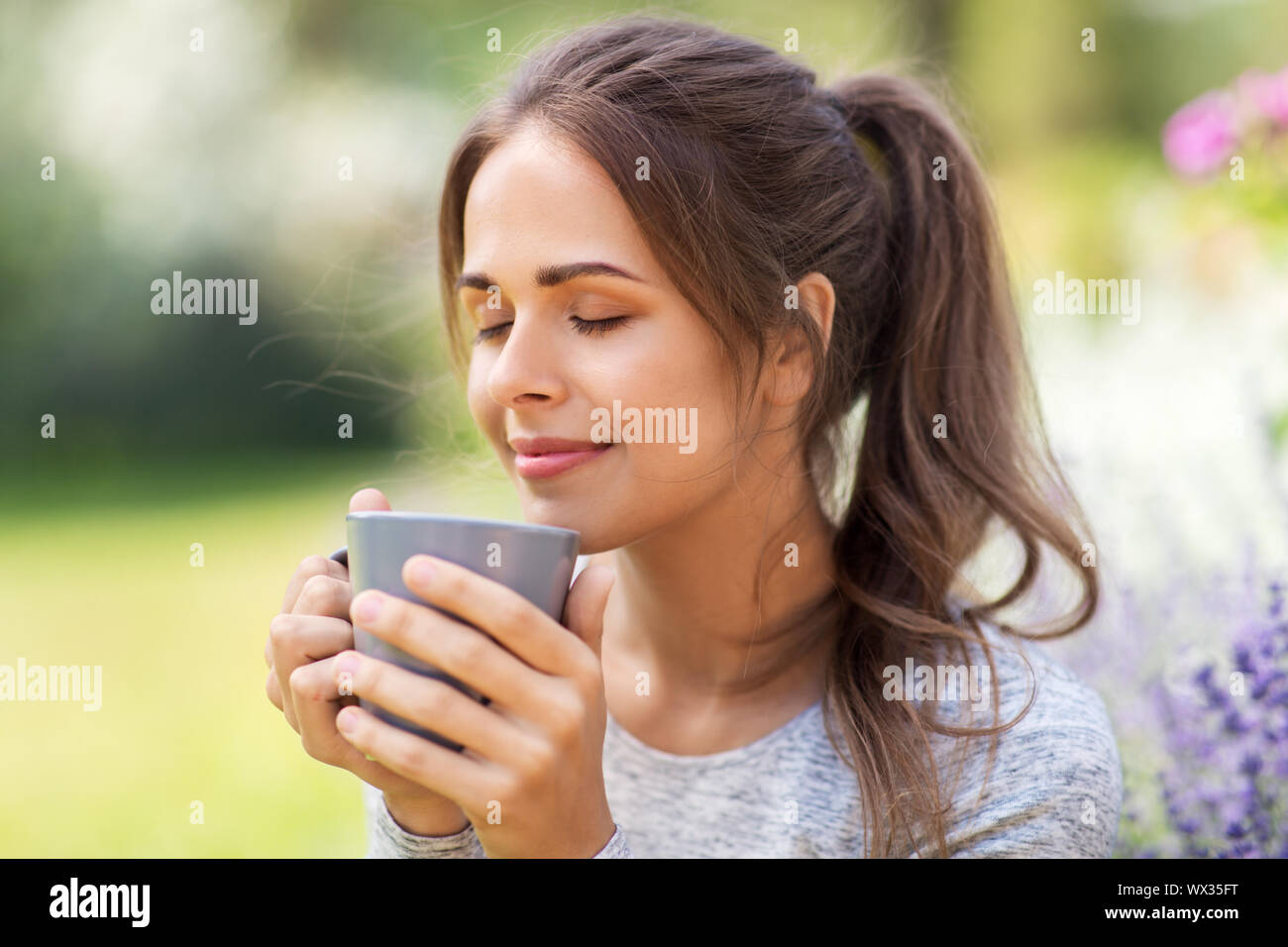 woman drinking tea or coffee at summer garden Stock Photo - Alamy