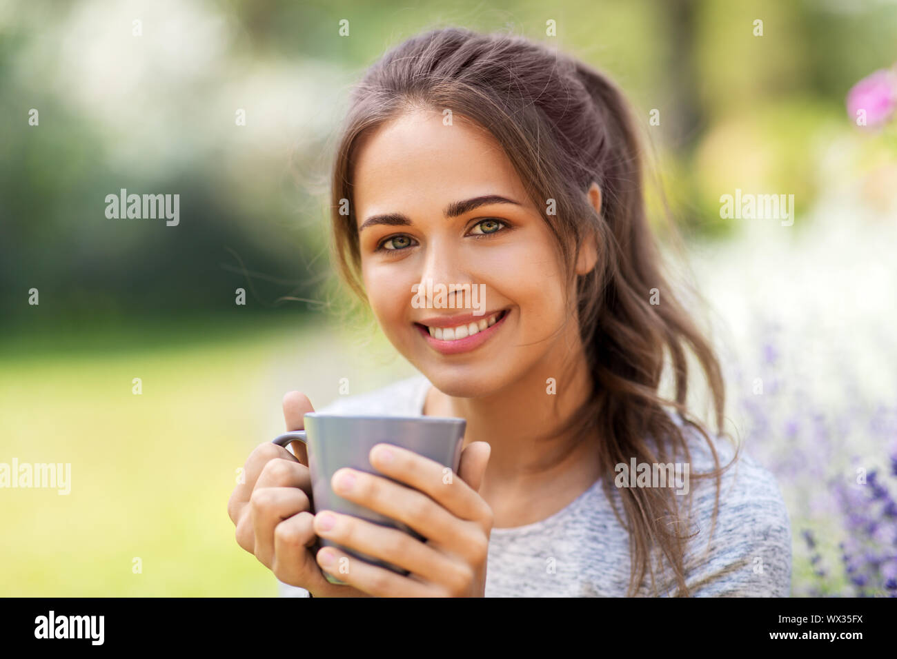 woman drinking tea or coffee at summer garden Stock Photo - Alamy
