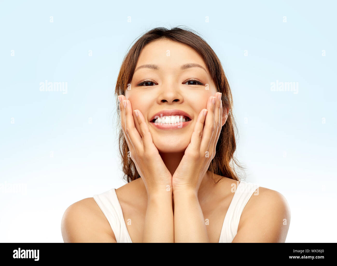 happy smiling young asian woman touching her face Stock Photo - Alamy