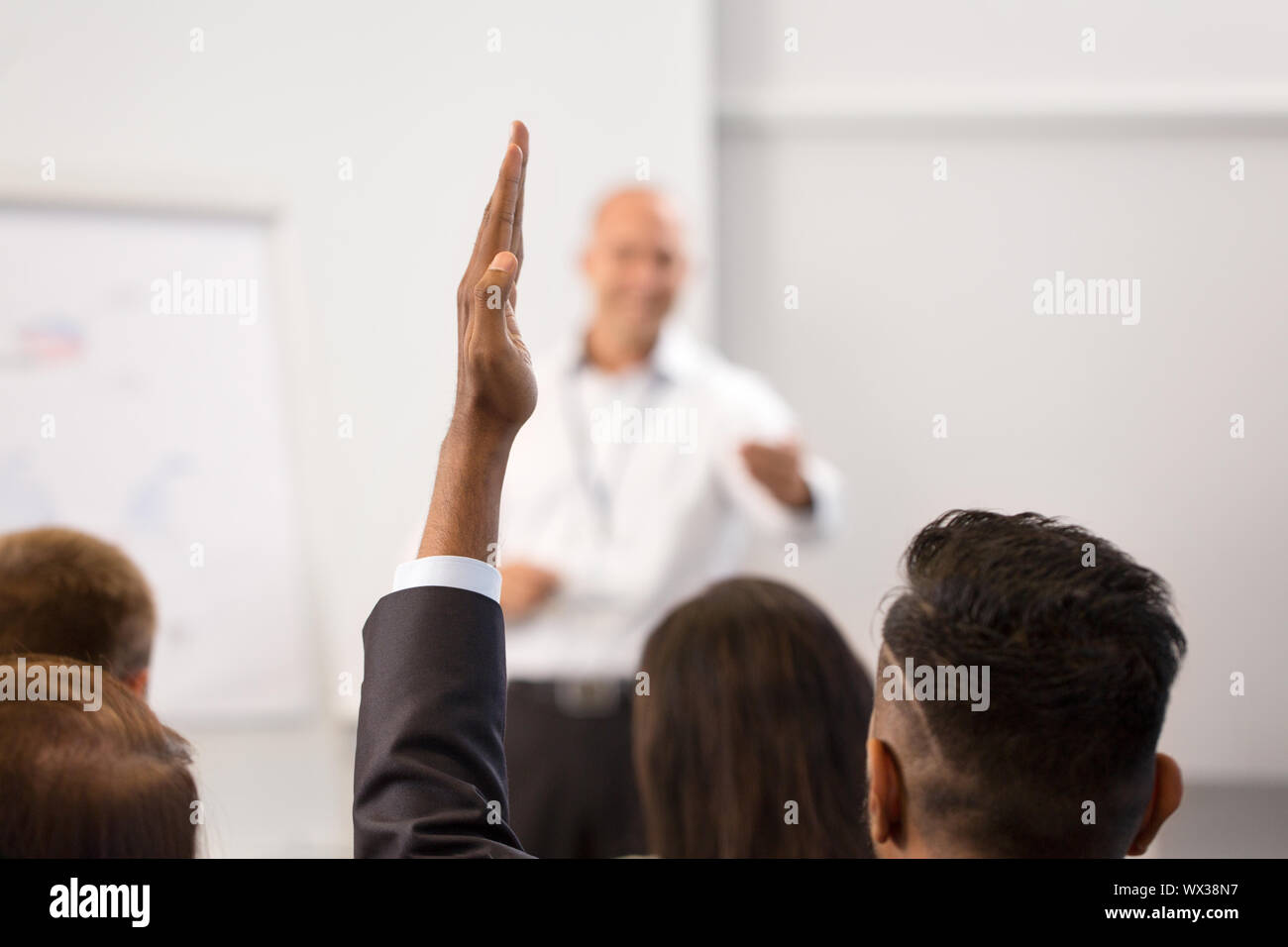 businessman raising hand at business conference Stock Photo - Alamy
