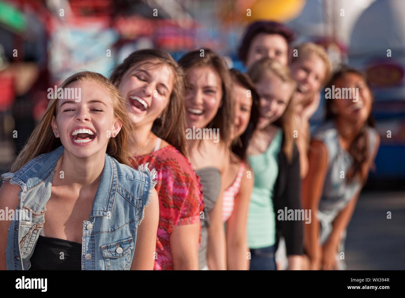 Group of eight girls in a row laughing Stock Photo - Alamy
