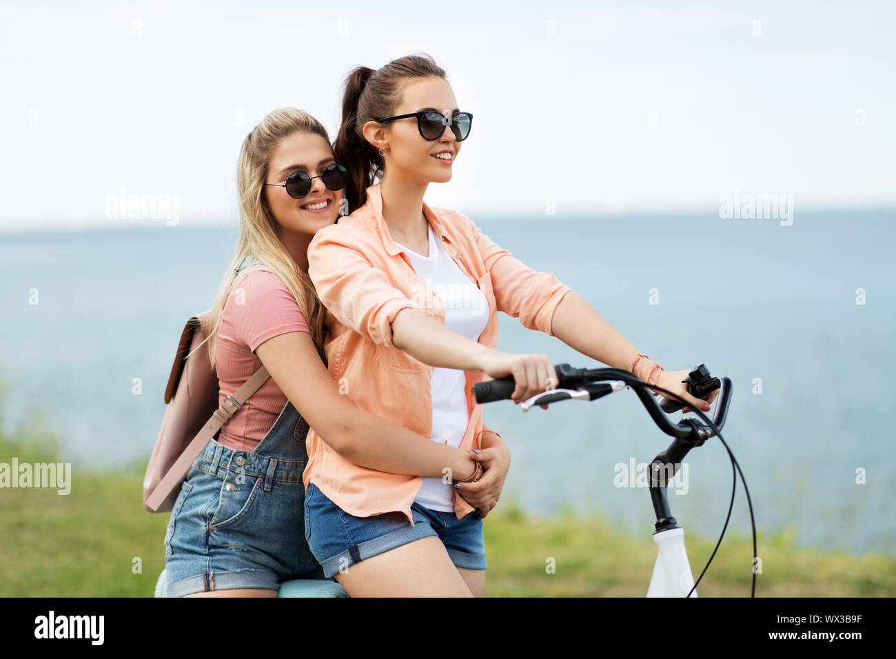 teenage girls or friends riding bicycle in summer Stock Photo - Alamy