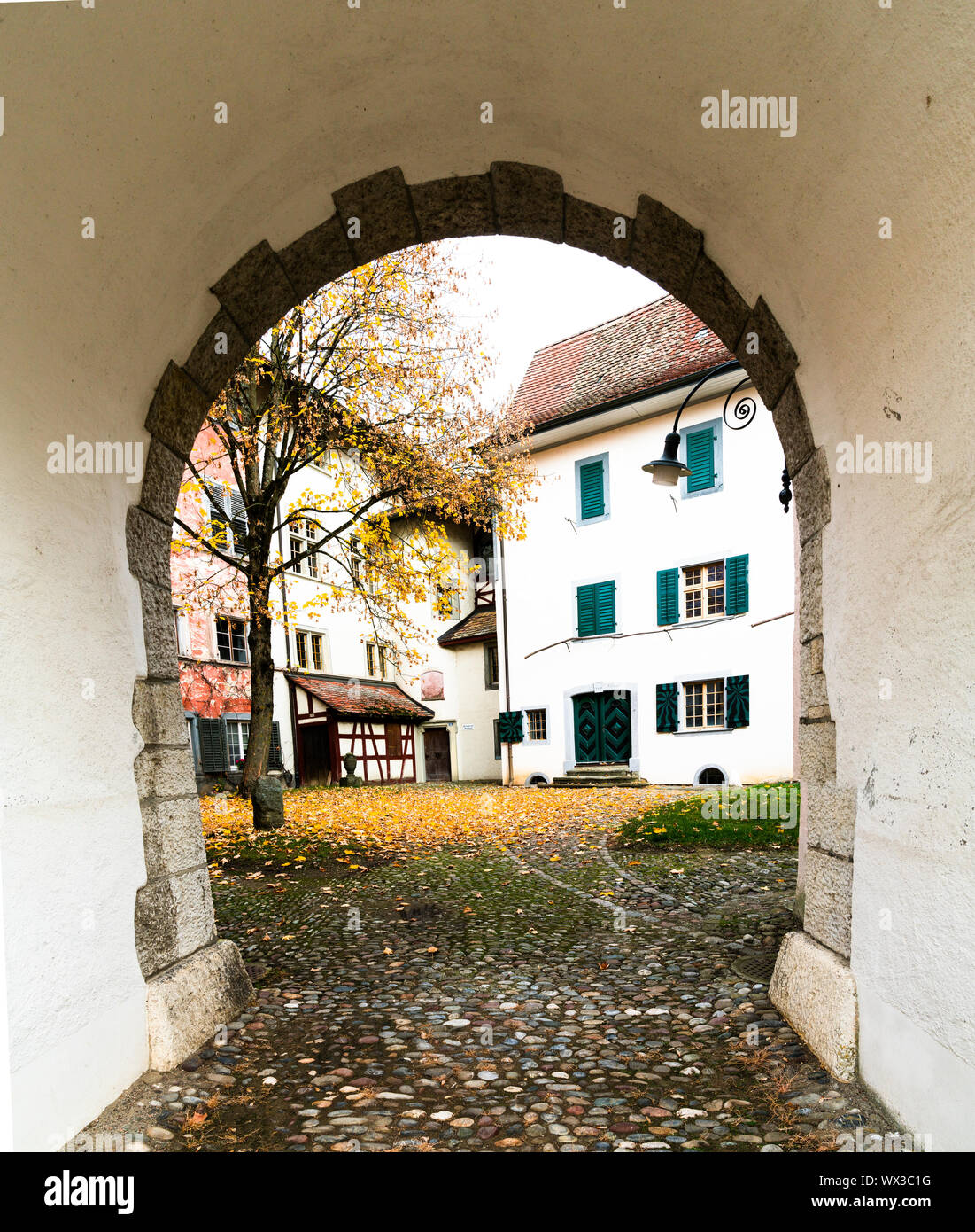 old stone gate city wall leading into an idyllic courtyard with ...