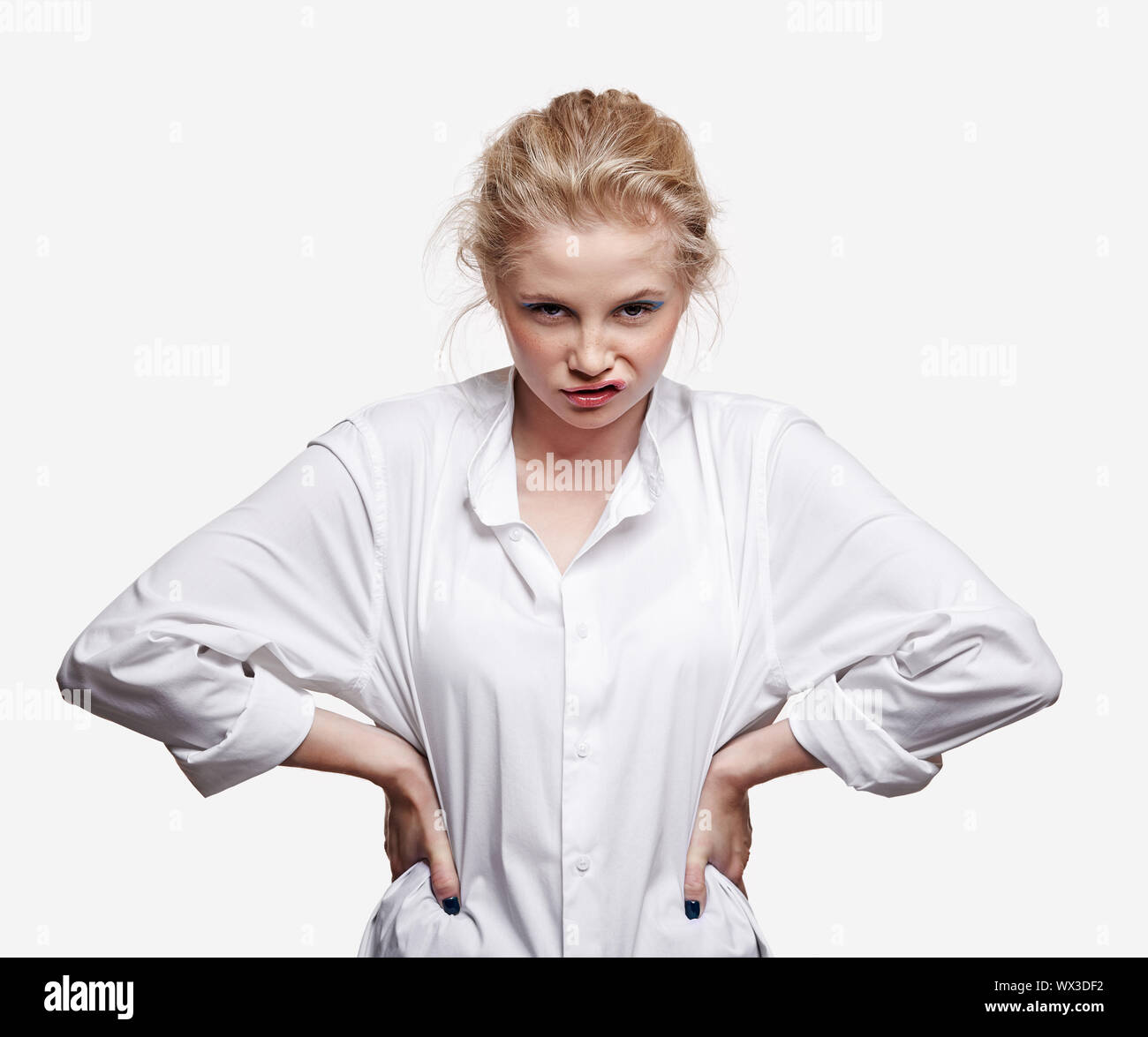 Female with grimace on face and hands on hips Stock Photo - Alamy