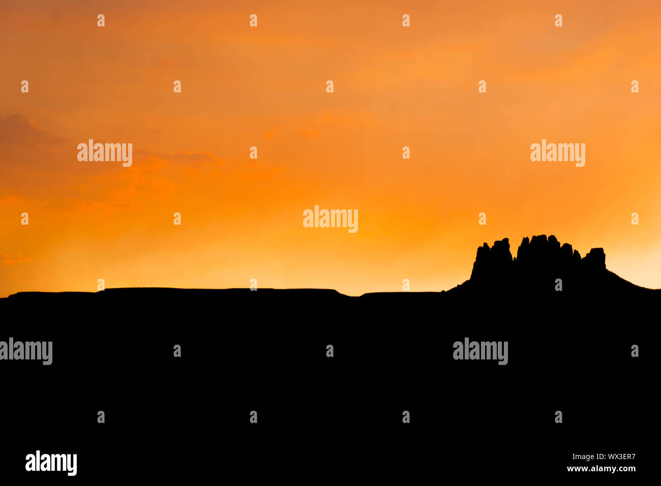 single rock mesa rock formation in the desert at sunset Stock Photo - Alamy
