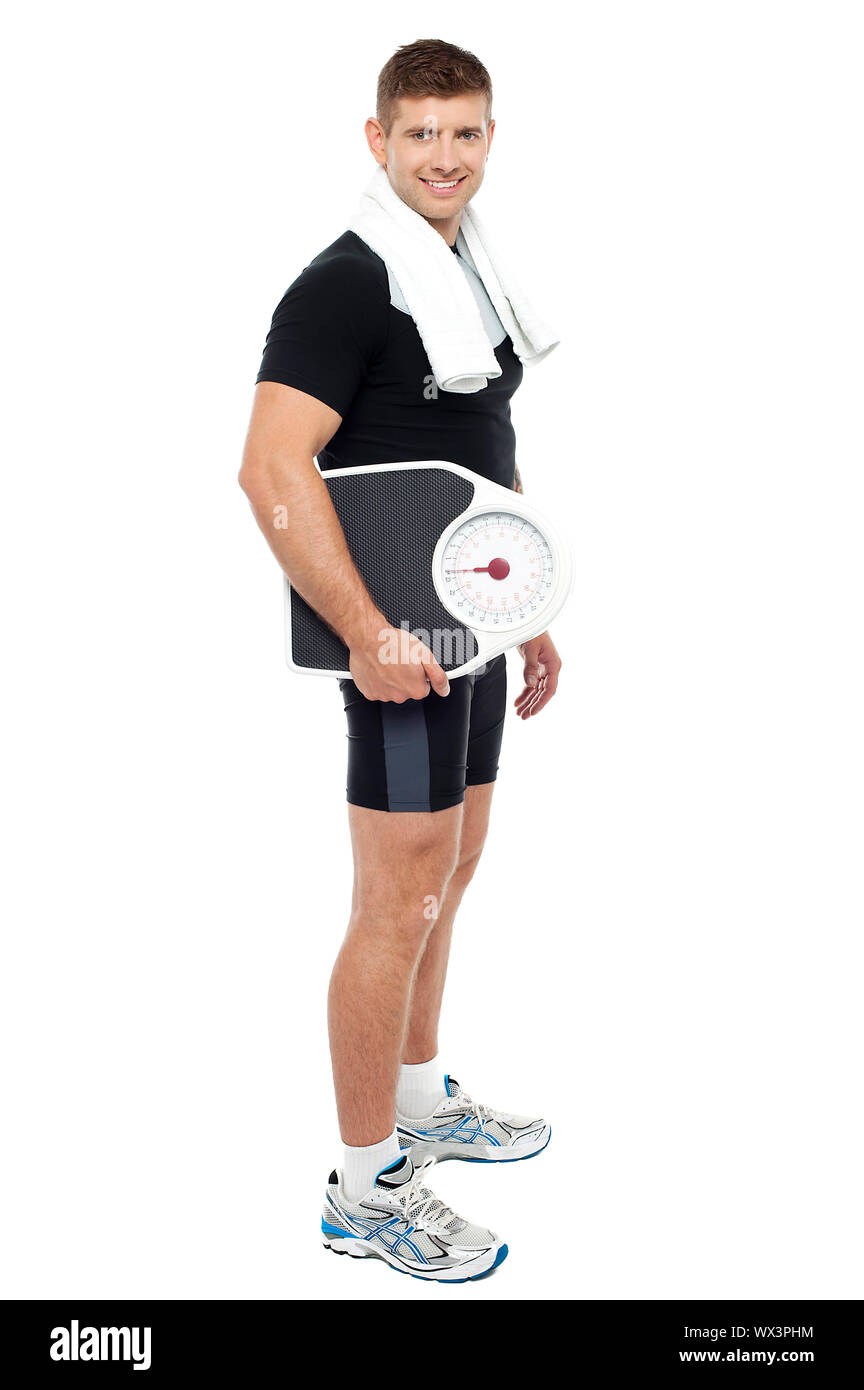 Full length portrait of young male carrying weight scale isolated ...