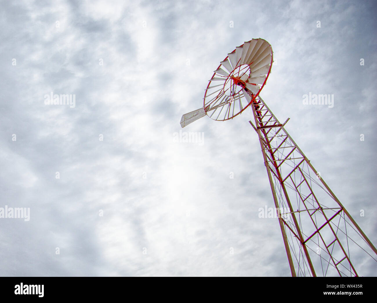 single old historic wind wheel or wind pump made of wood and metal up ...