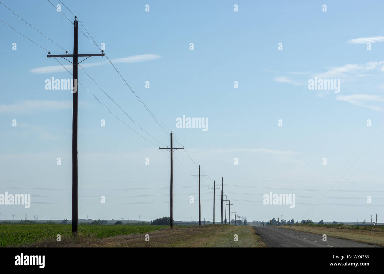 country road in the empty Texas prairie with an endless expanse of blue ...