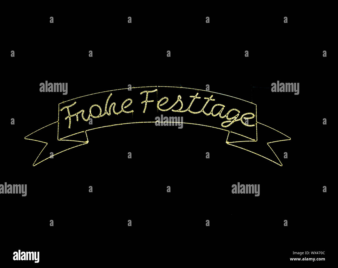 illuminated sign in the night sky with the words Frohe Festtage meaning ...