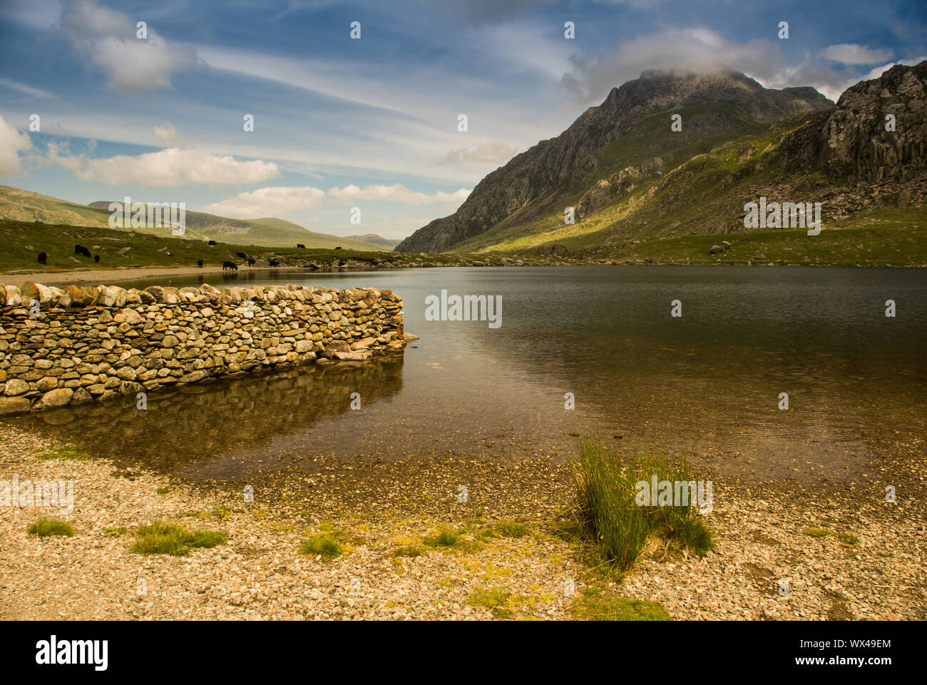 Stone wall jutting out into Llyn Idwal in Snowdonia, North Wales Stock ...