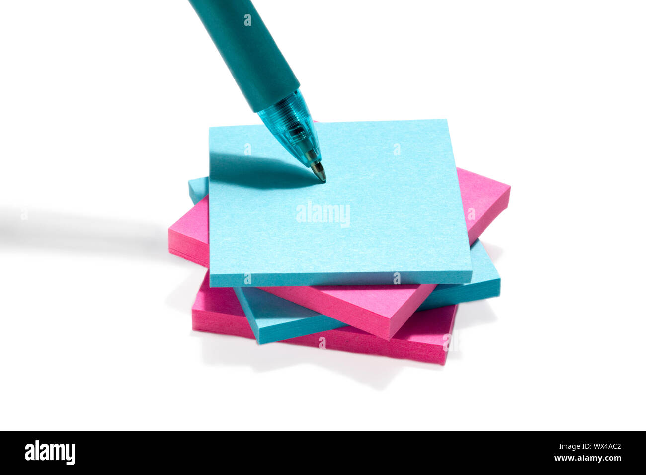 Image of blue and pink post it note paper with pen against the white ...