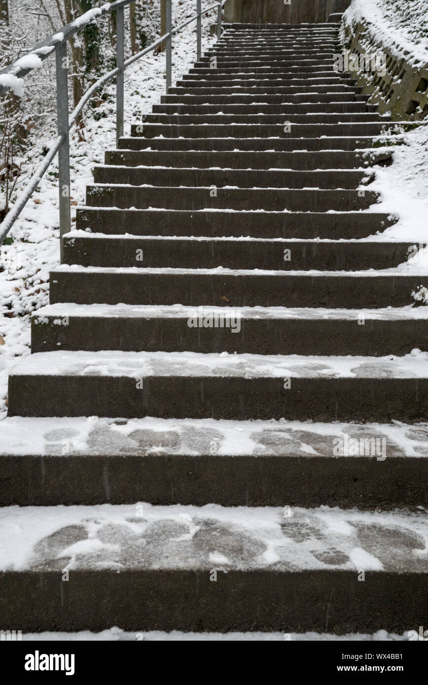 long snow covered stairs in winter with foot steps and tracks Stock ...