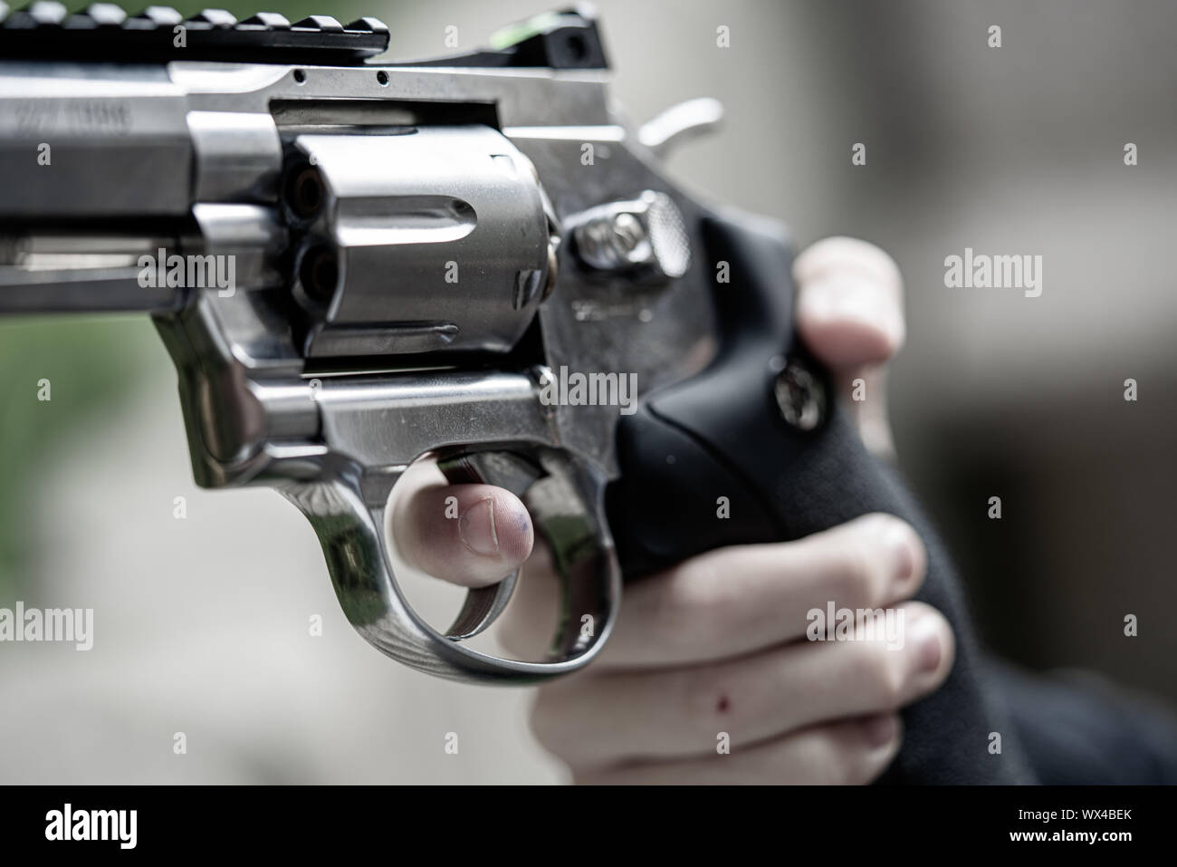 in one hand is large silver heavy revolver and aims into the air Stock ...