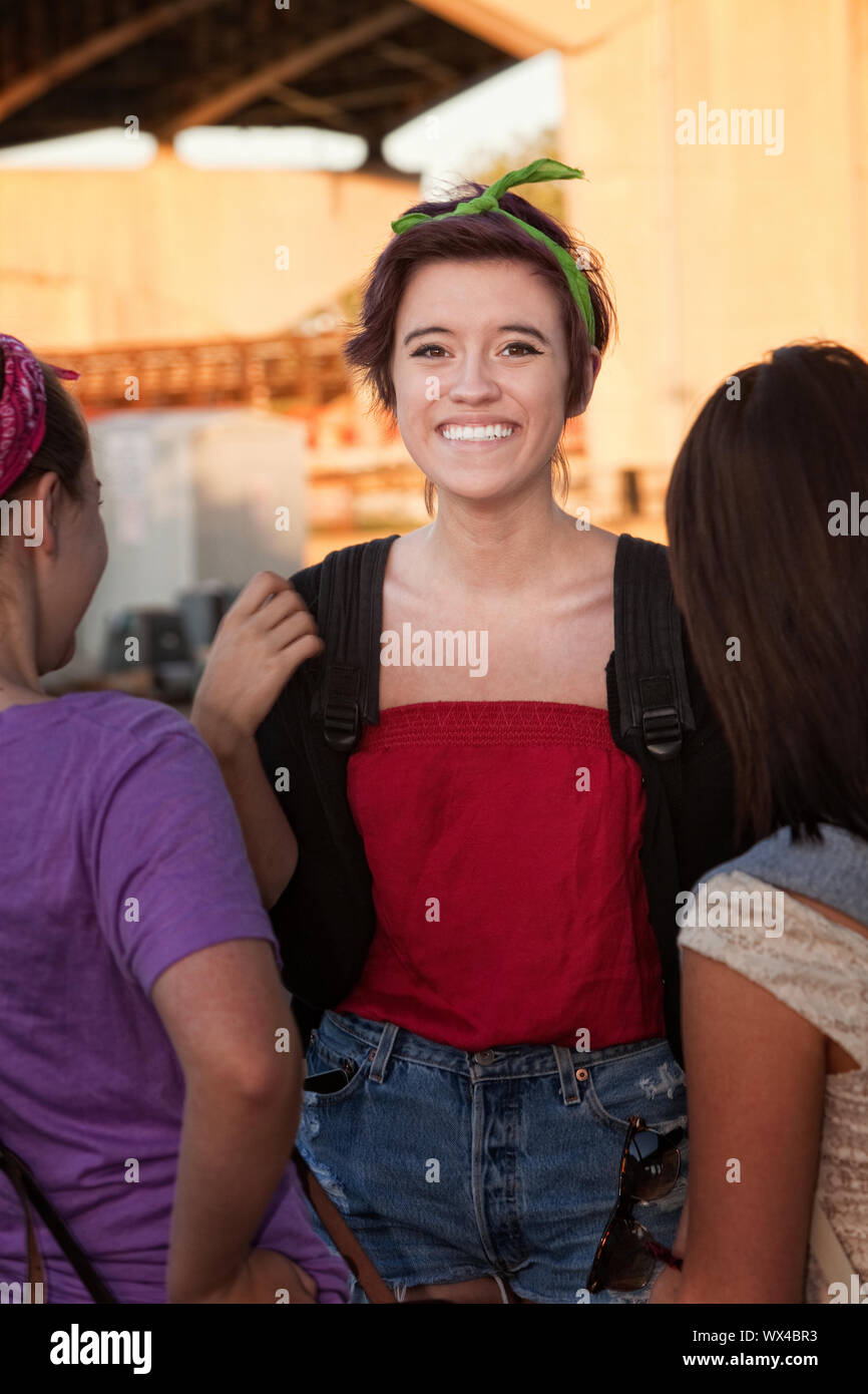 Flattered teenage girl talking with friends outdoors Stock Photo - Alamy