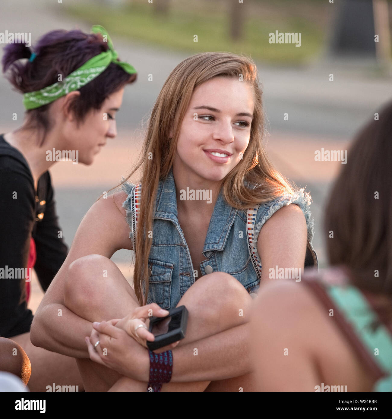 Pretty young teenage girl holding phone and smiling Stock Photo - Alamy