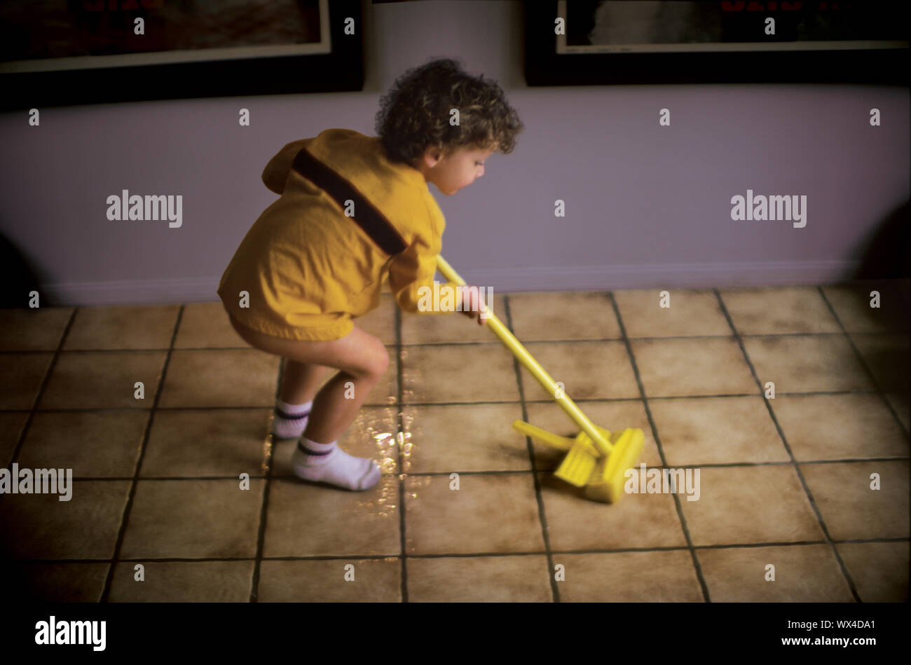 A little kid trying his hand at mopping the floor Stock Photo - Alamy