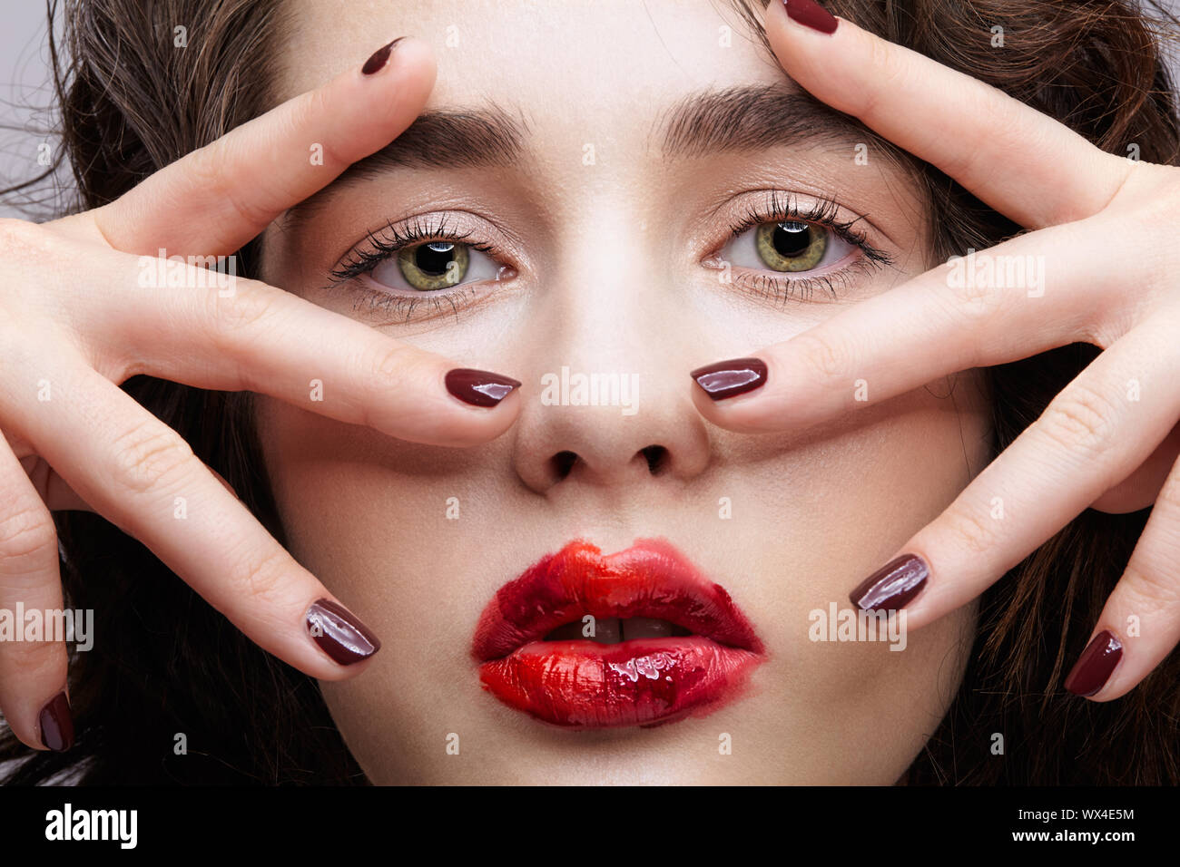 Brunette girl with unusual alyapy red female face makeup Stock Photo ...
