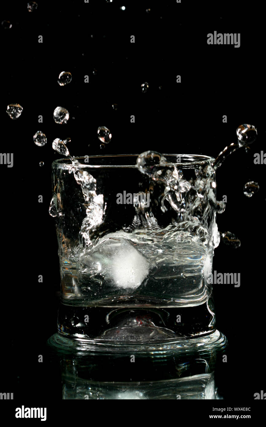 alcohol splash on black background close up Stock Photo - Alamy