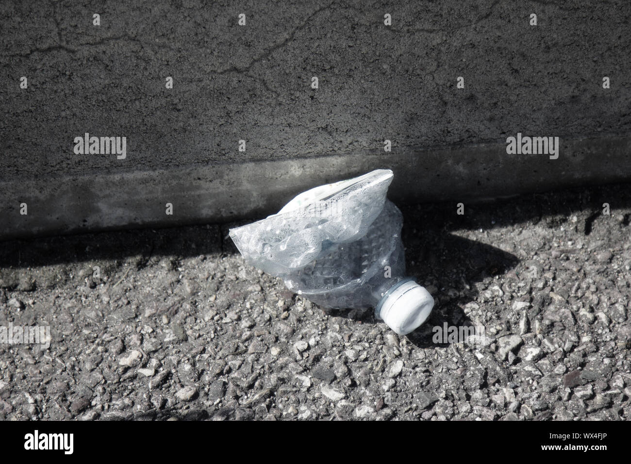 Plastic pollution of cities. Thrown on the side of road the crumpled ...