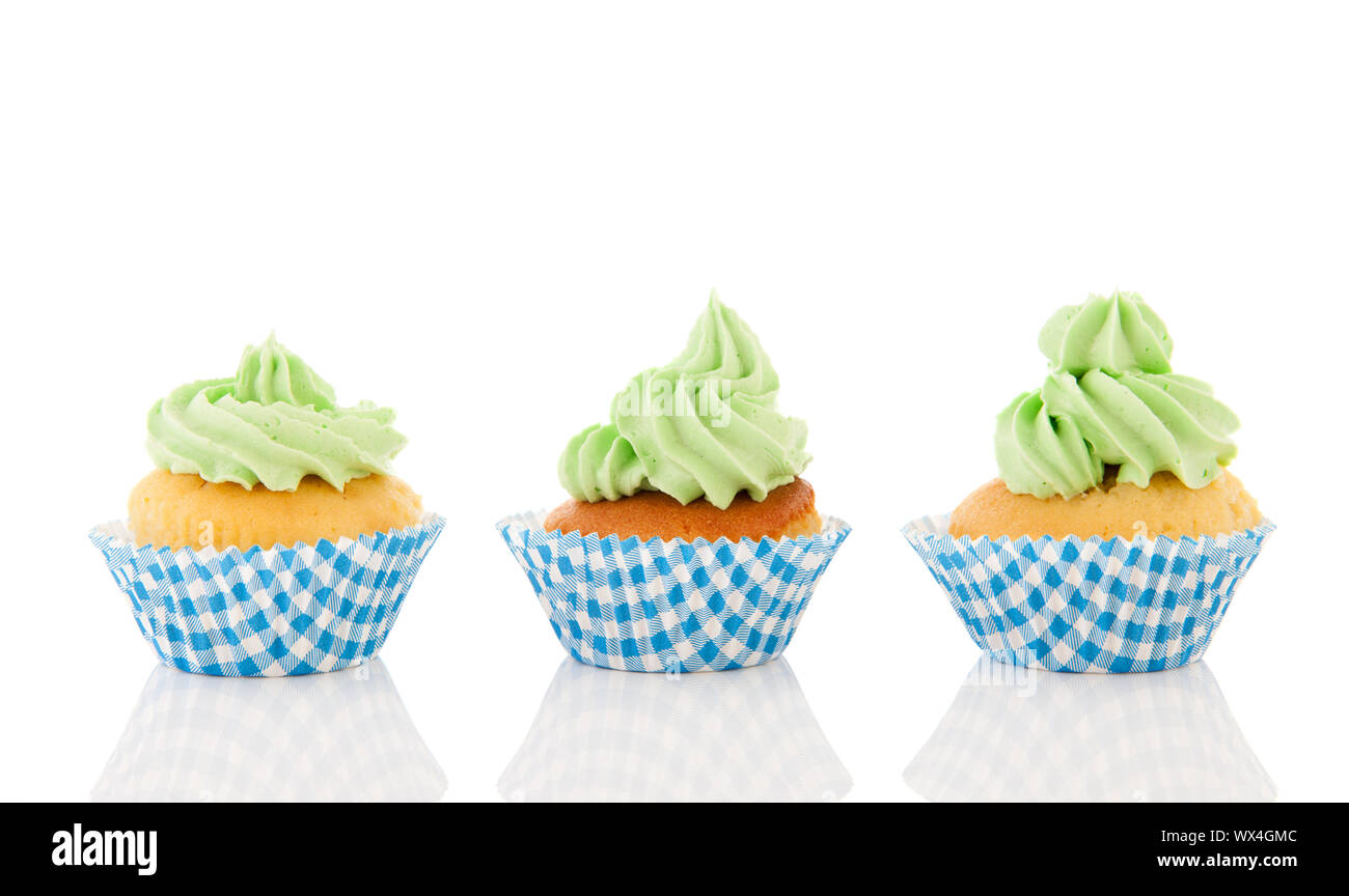 Blue and green cupcakes with butter cream isolated over white ...