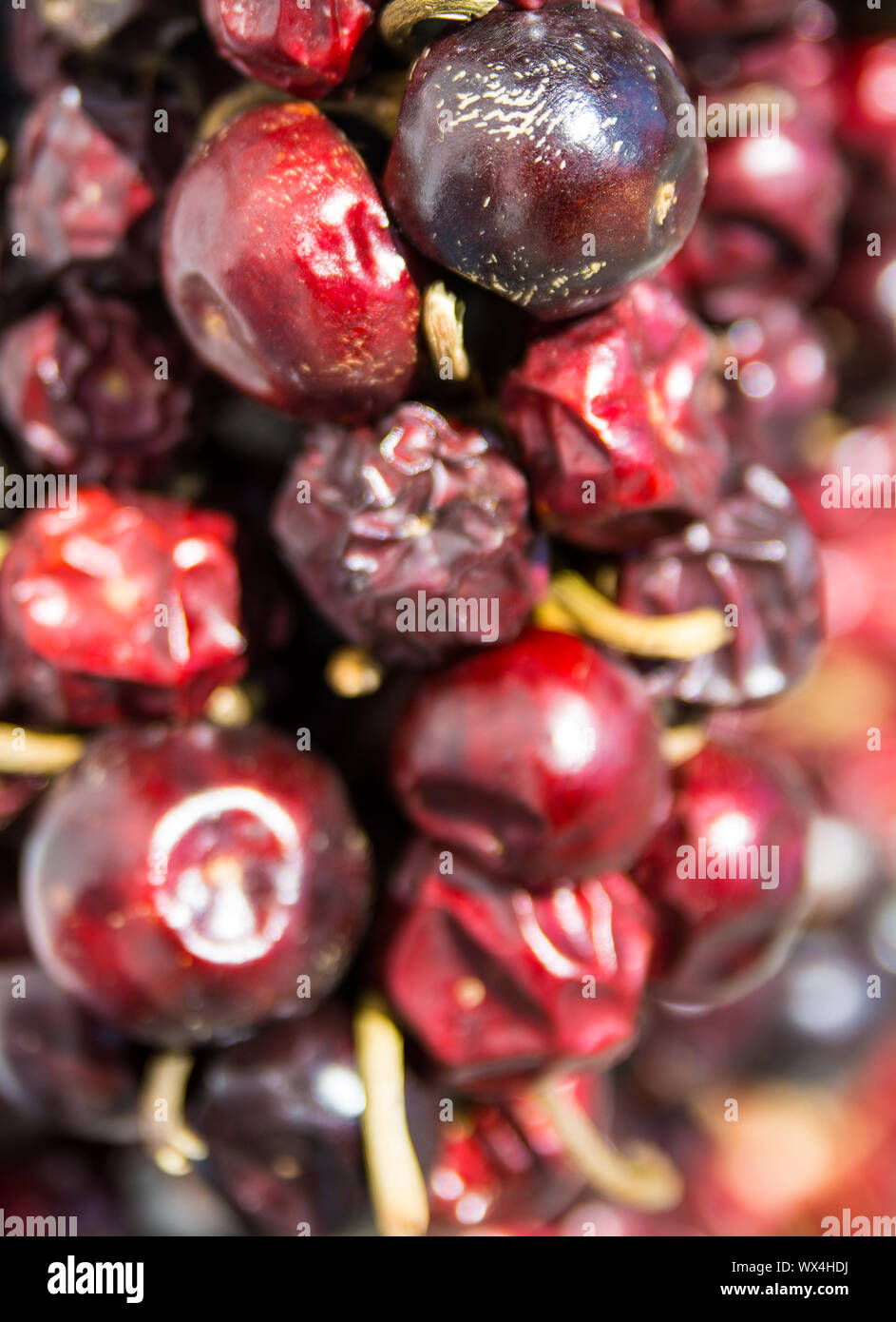 Dried round red chilli on a market stall with out of focus areas on the ...