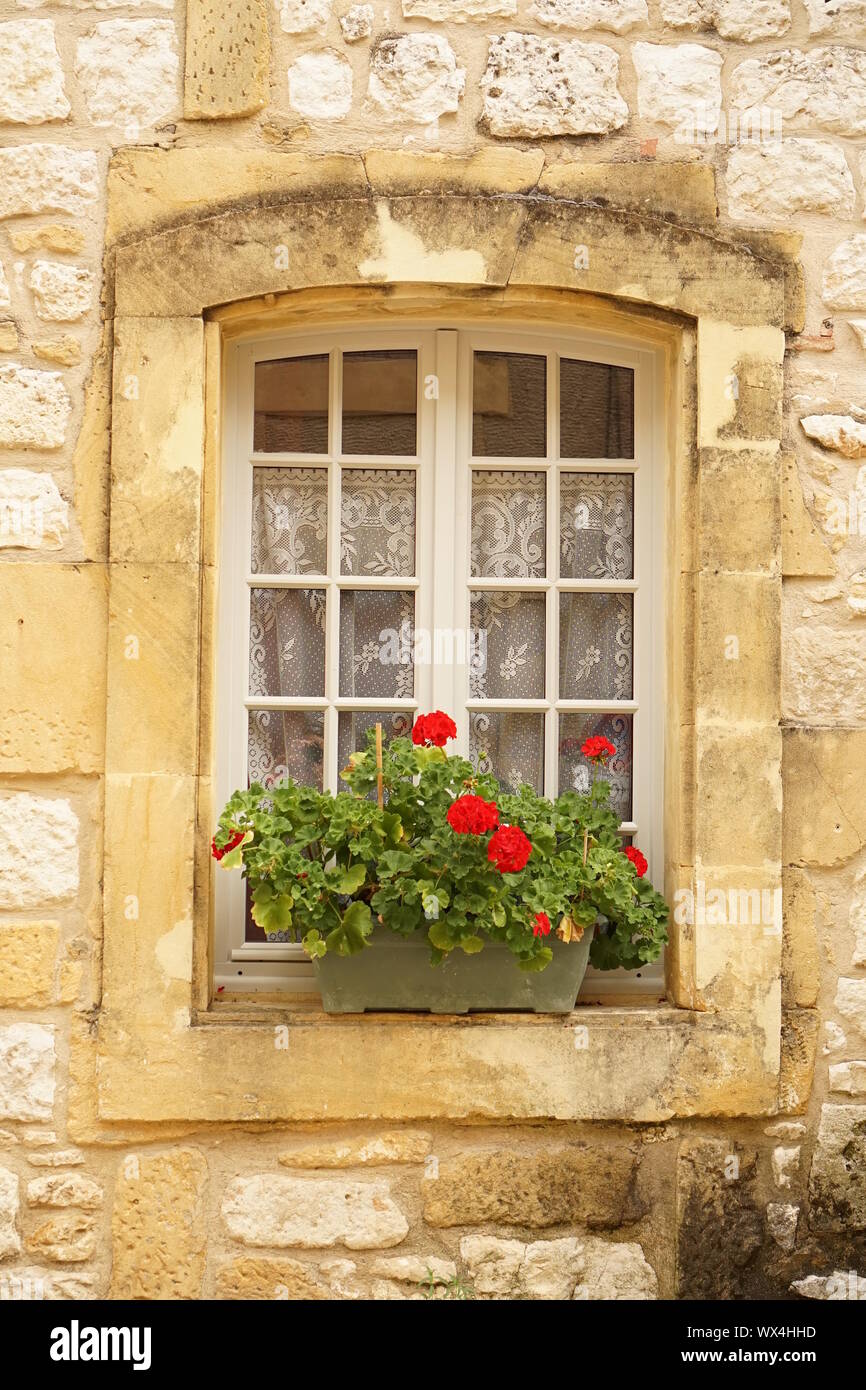 A colonial white window and stone windowsill and frame with flowers ...