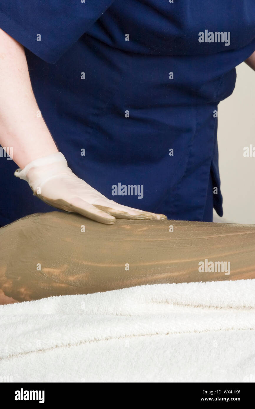 Sea mud for a full body wrap being applied to a leg a luxury spa Stock ...