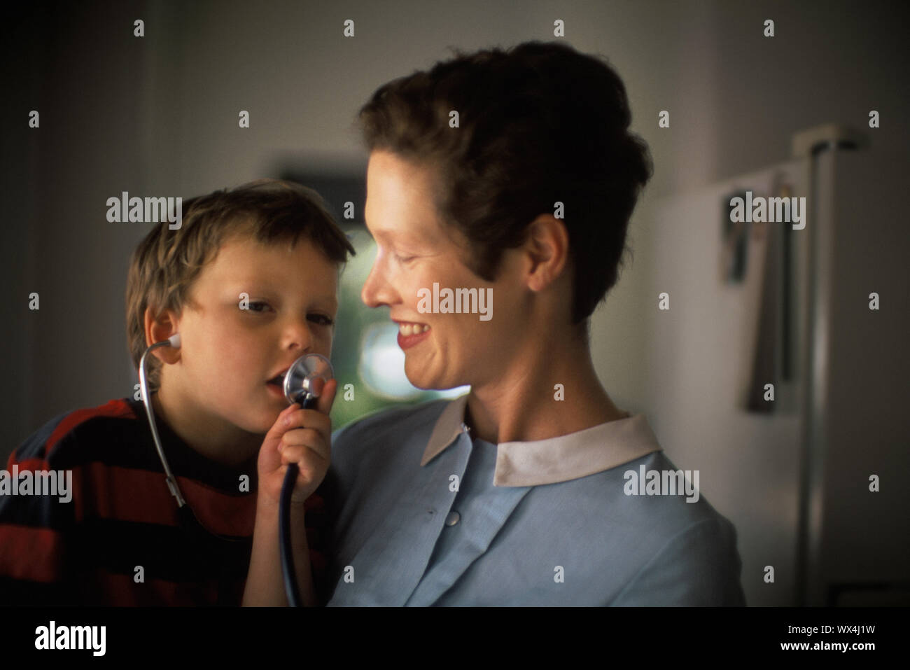 A kid playing with a stethoscope as a nurse looks on Stock Photo - Alamy