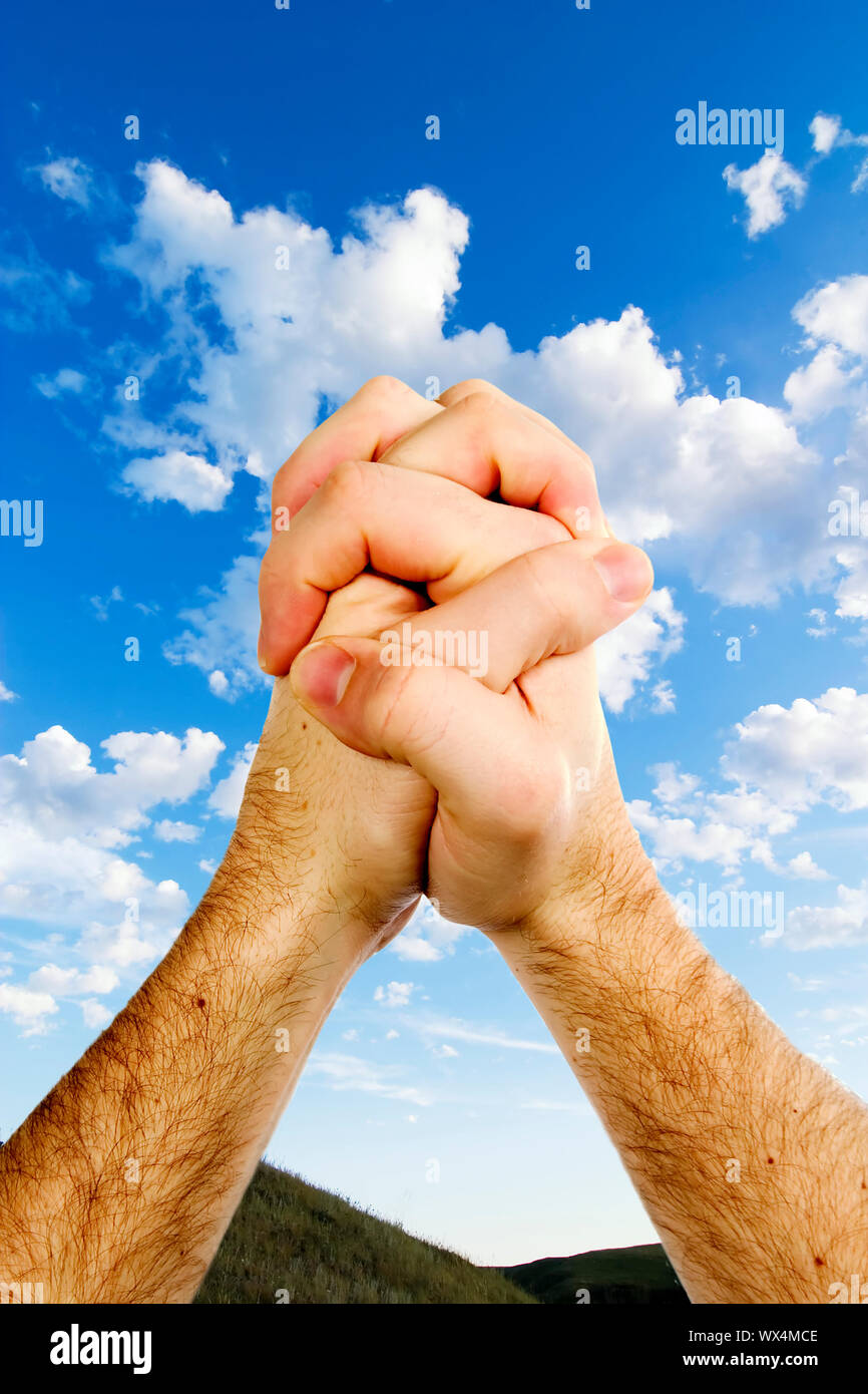 Praying hands on top of a beautiful prairie landscape with a deep blue ...