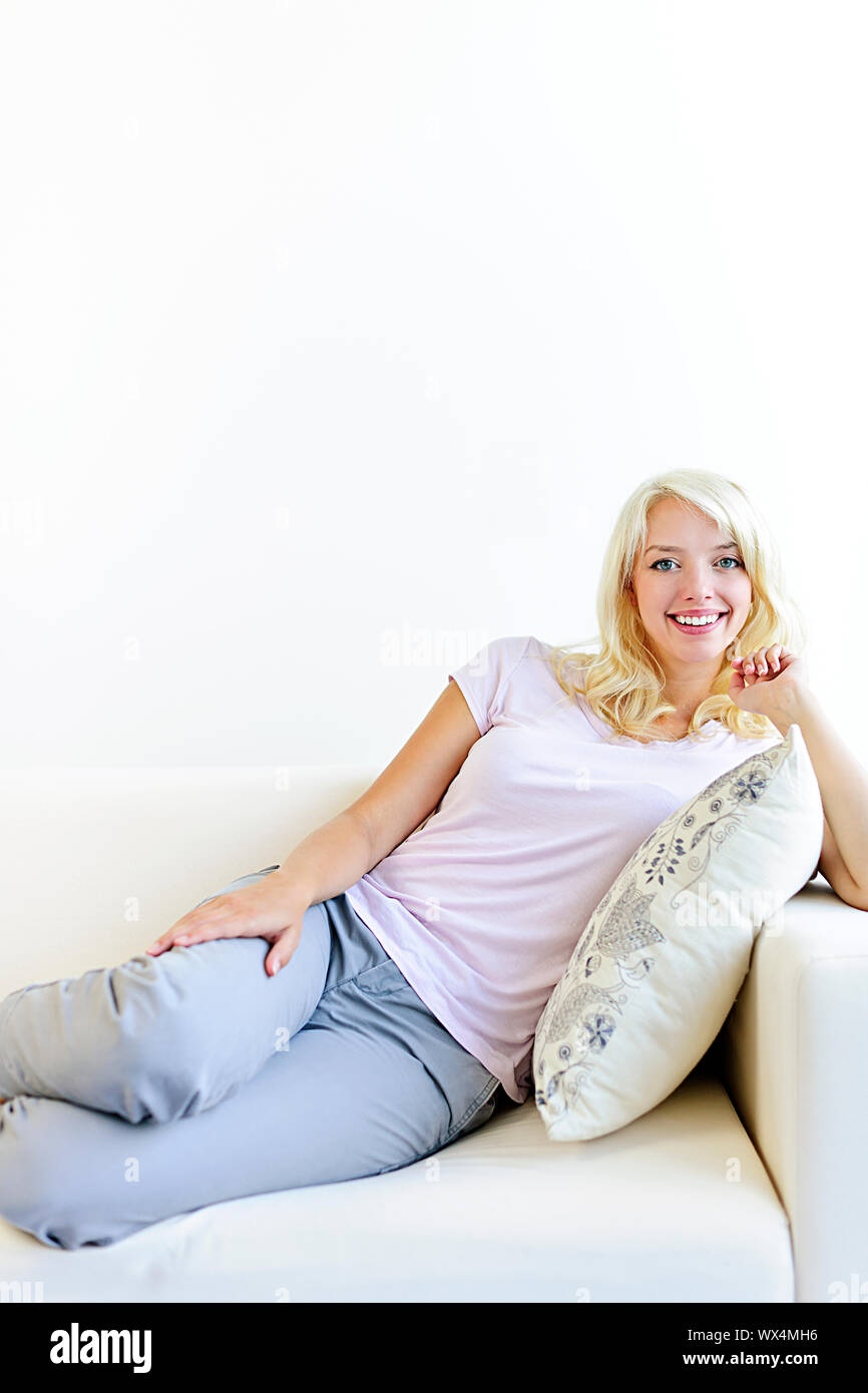 Beautiful blonde woman reclining on couch and relaxing at home Stock ...