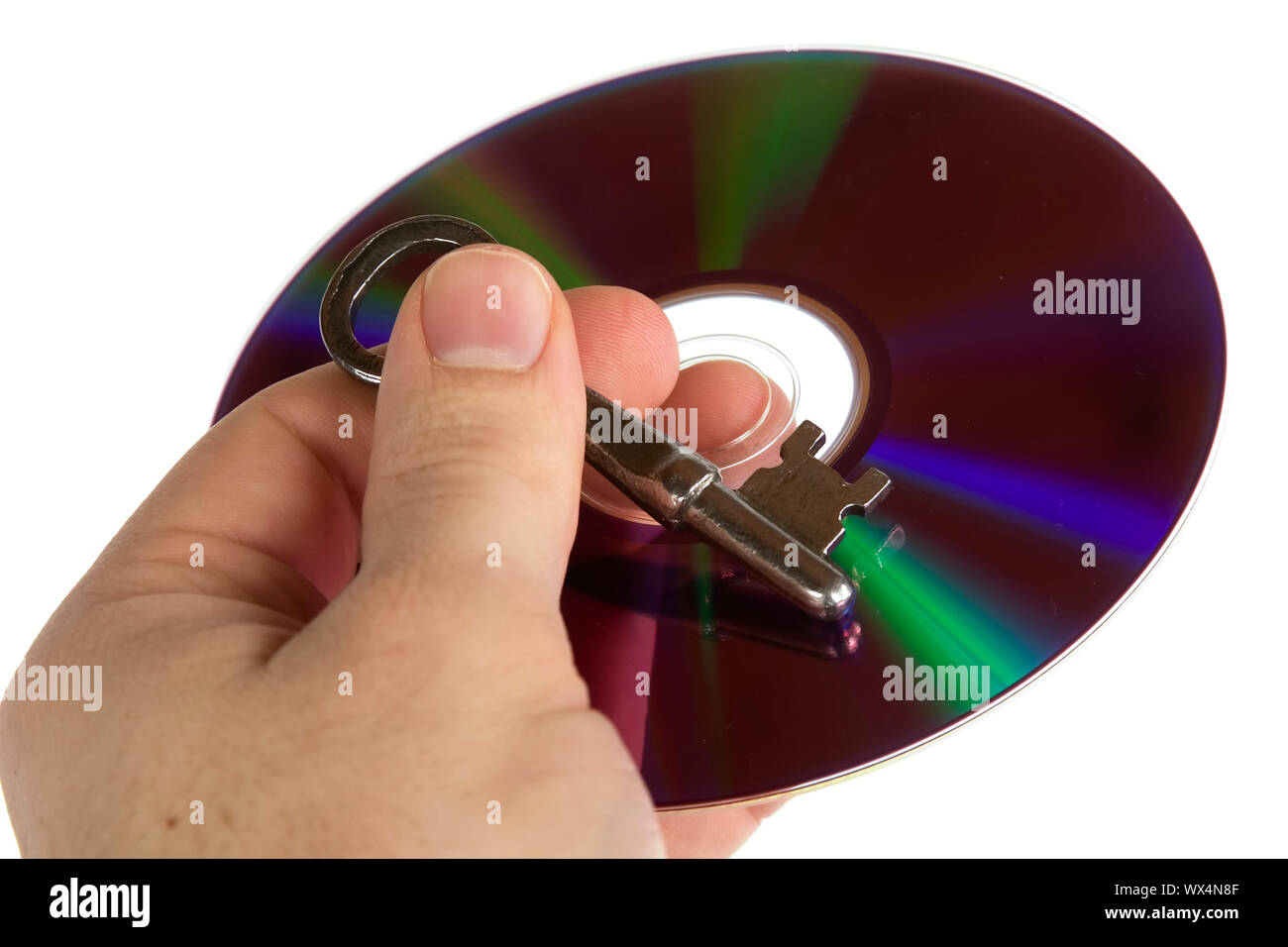 A skeleton key and a computer disk being held by a males hand, isolated ...