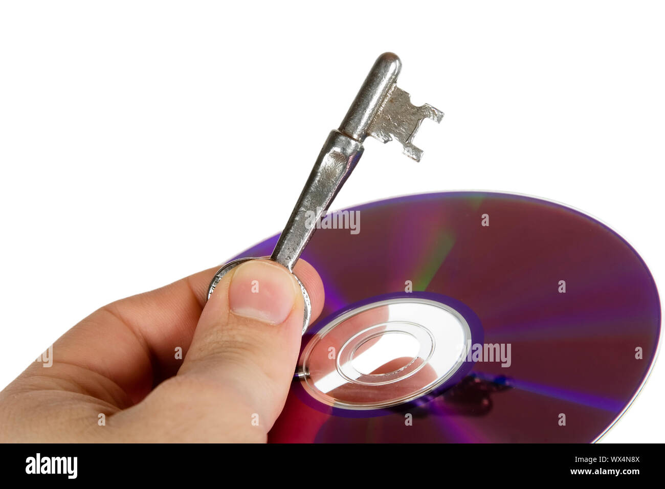 A skeleton key and a computer disk being held by a males hand, isolated ...