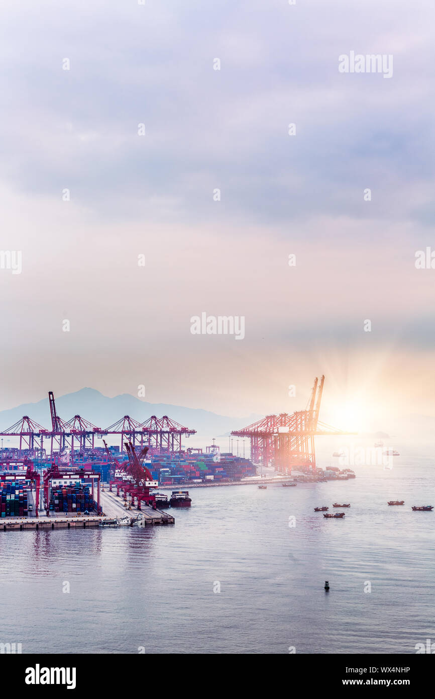 Cargo ship in the harbor at sunset Stock Photo - Alamy