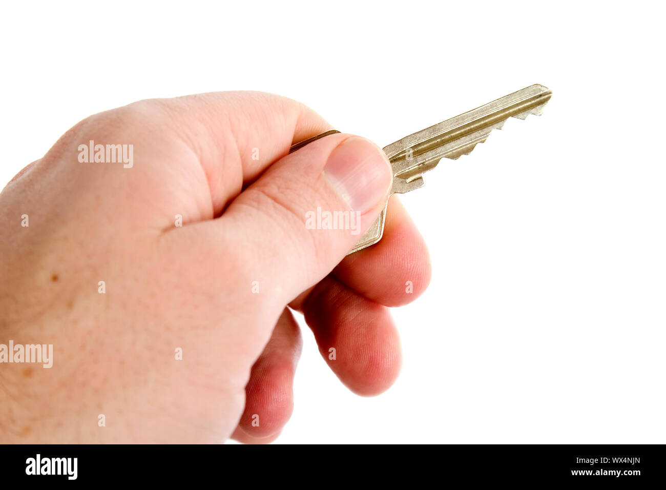 A standard key being held in a male hand. Isolated on white with ...
