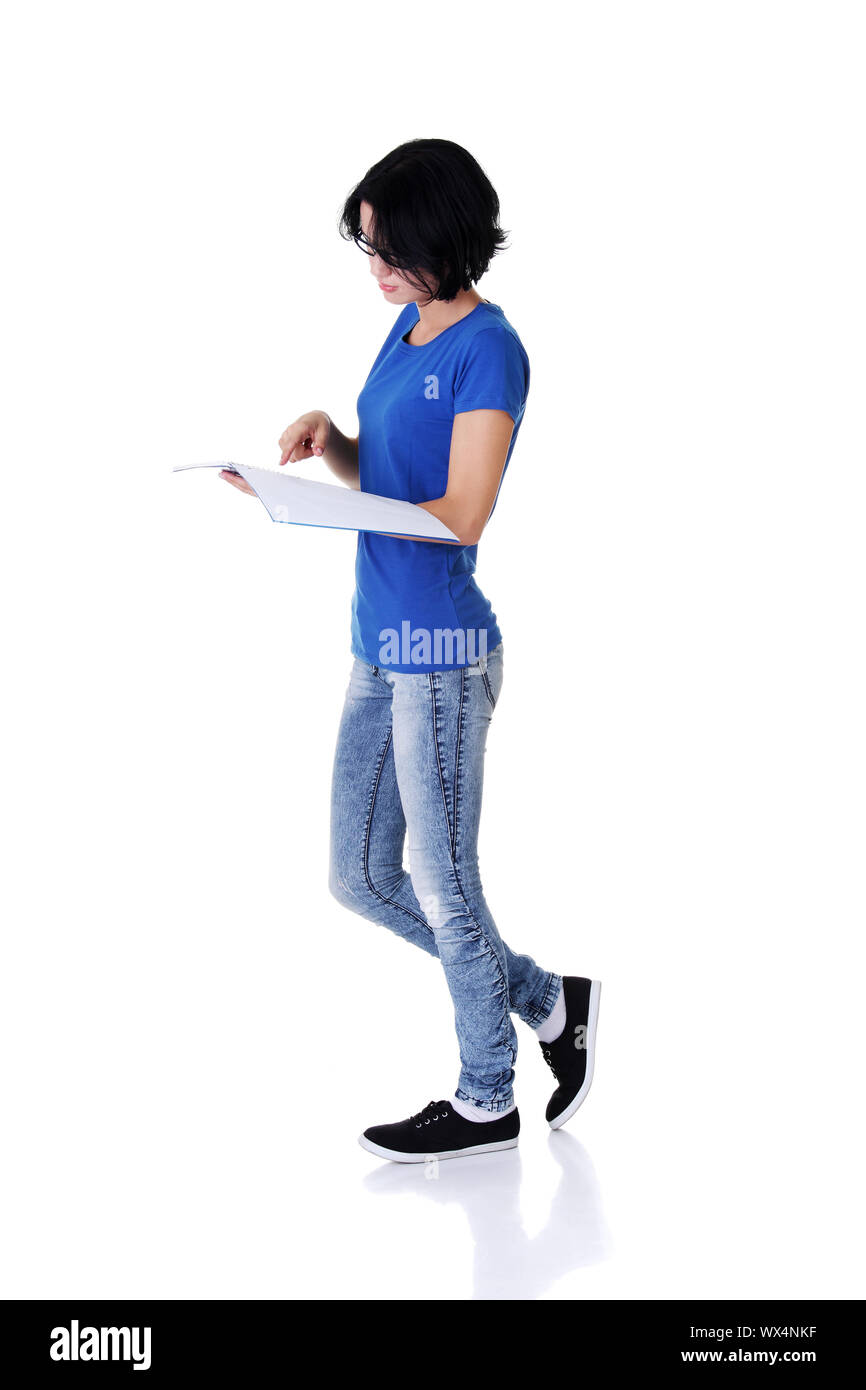 Studying thoughtful young woman reading notes in her notebook for ...